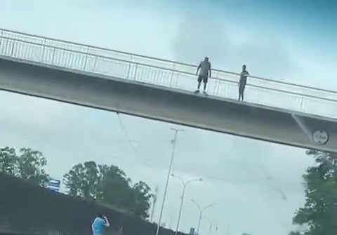 A Man's Leap From A Bridge Onto A Paved Road